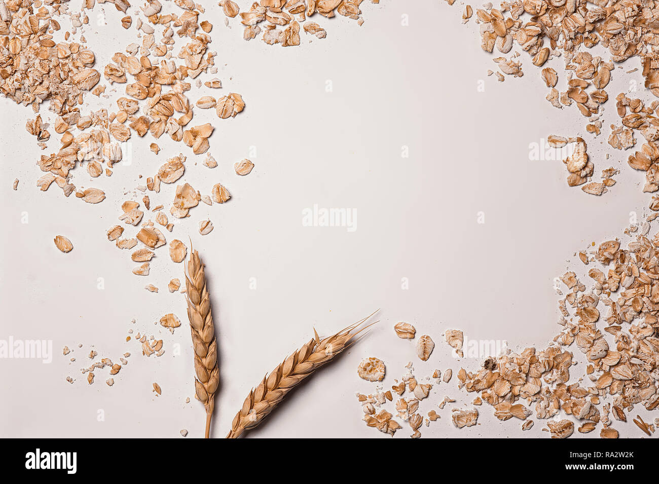 bundle of oat plant with oatmeal on creamy background. Place for text ...