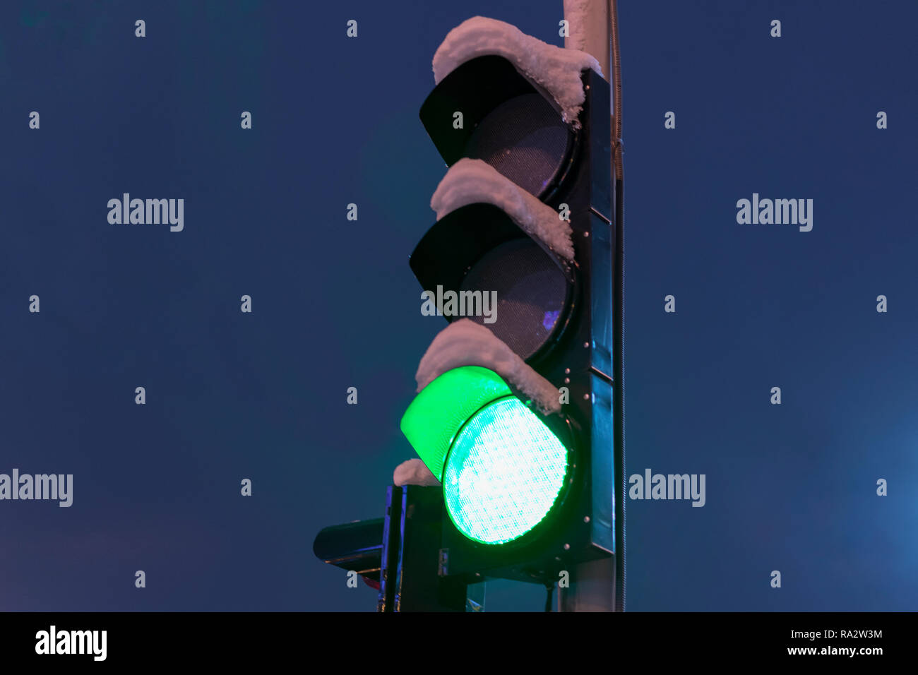 Green light traffic light on a dark background. A closeup photo of ...