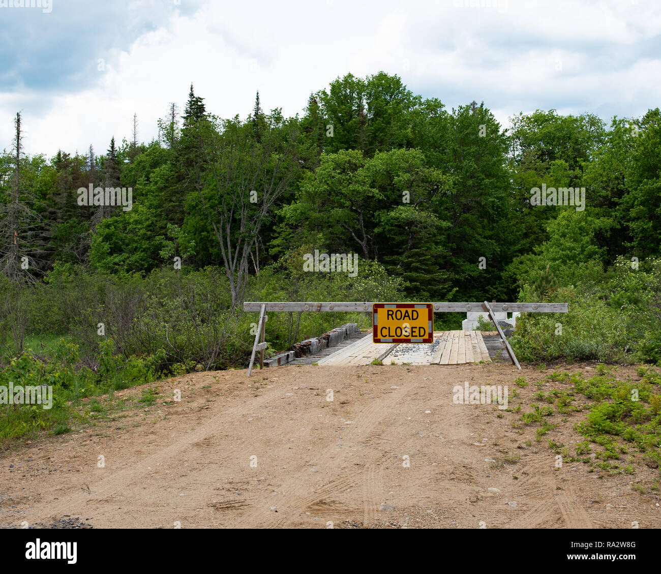 A road closed sign and barricade blocking off a condemned wooden ...