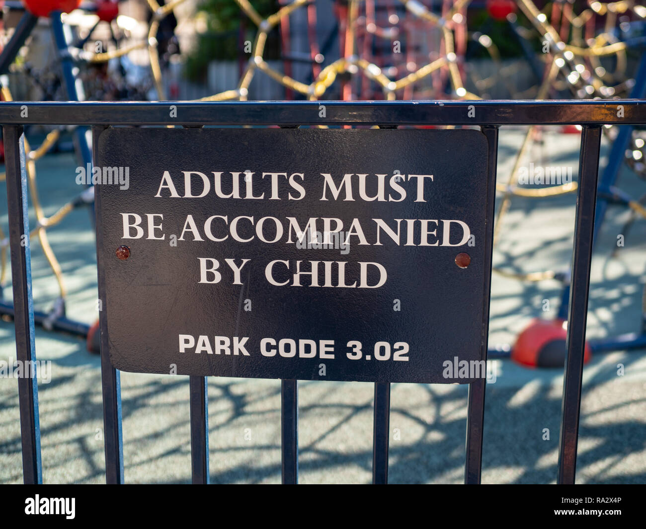 Adults must be accompanied by child park warning sign Stock Photo - Alamy