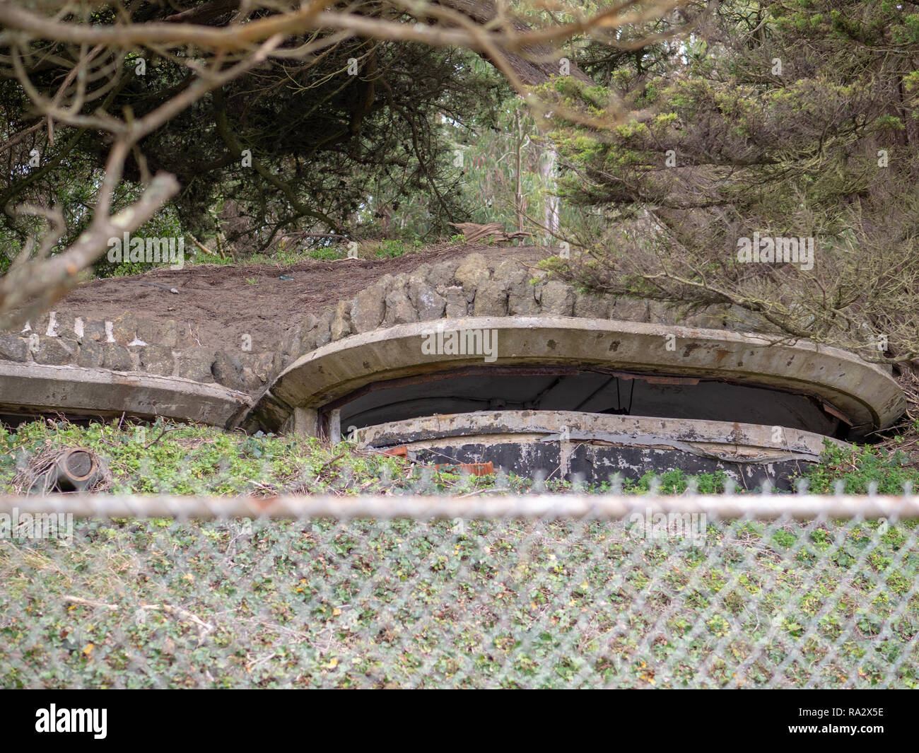 Military bunker hidden in a hill in front of steel fence Stock Photo ...