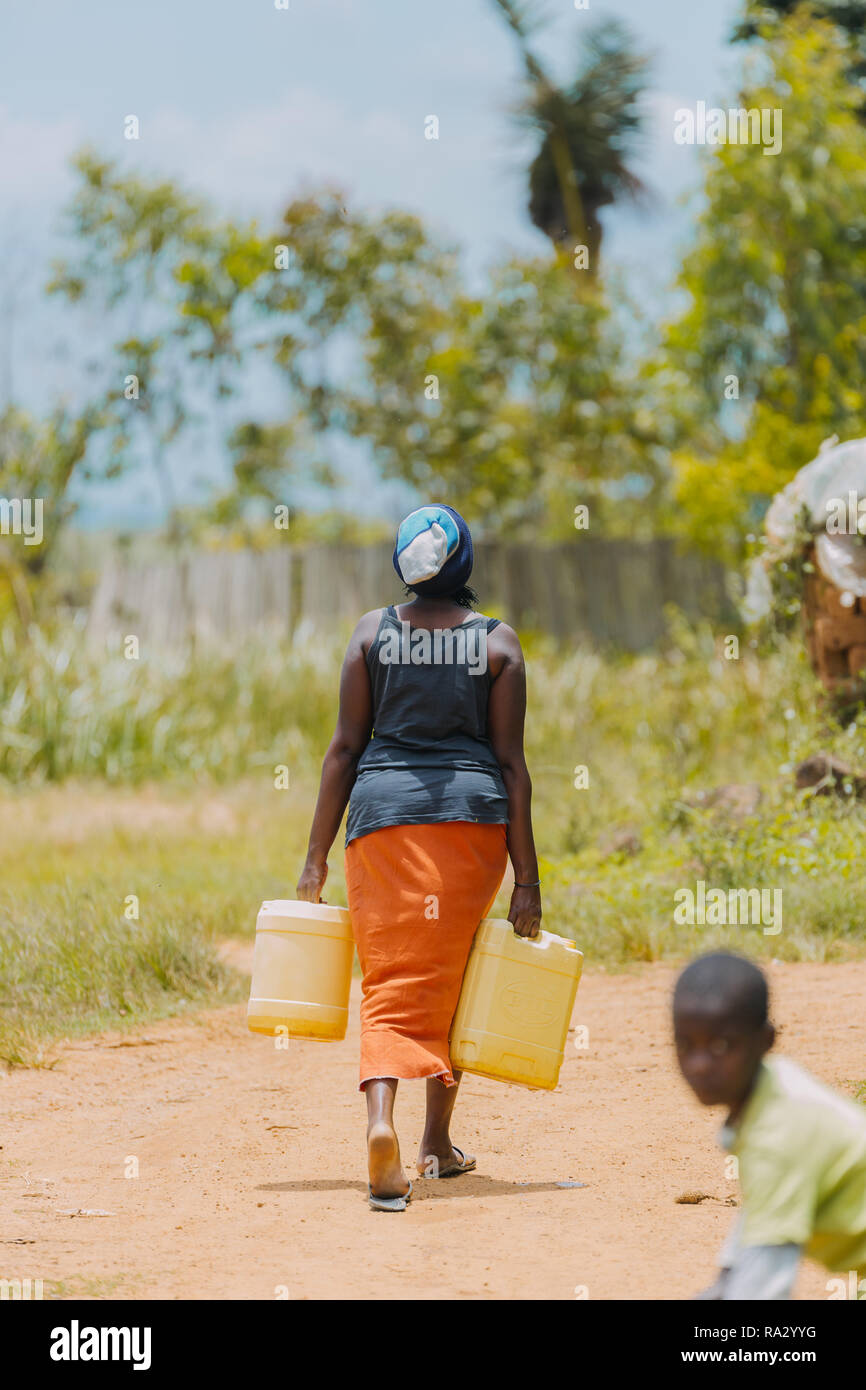 Woman carrying water in Entebbe, Uganda Stock Photo - Alamy