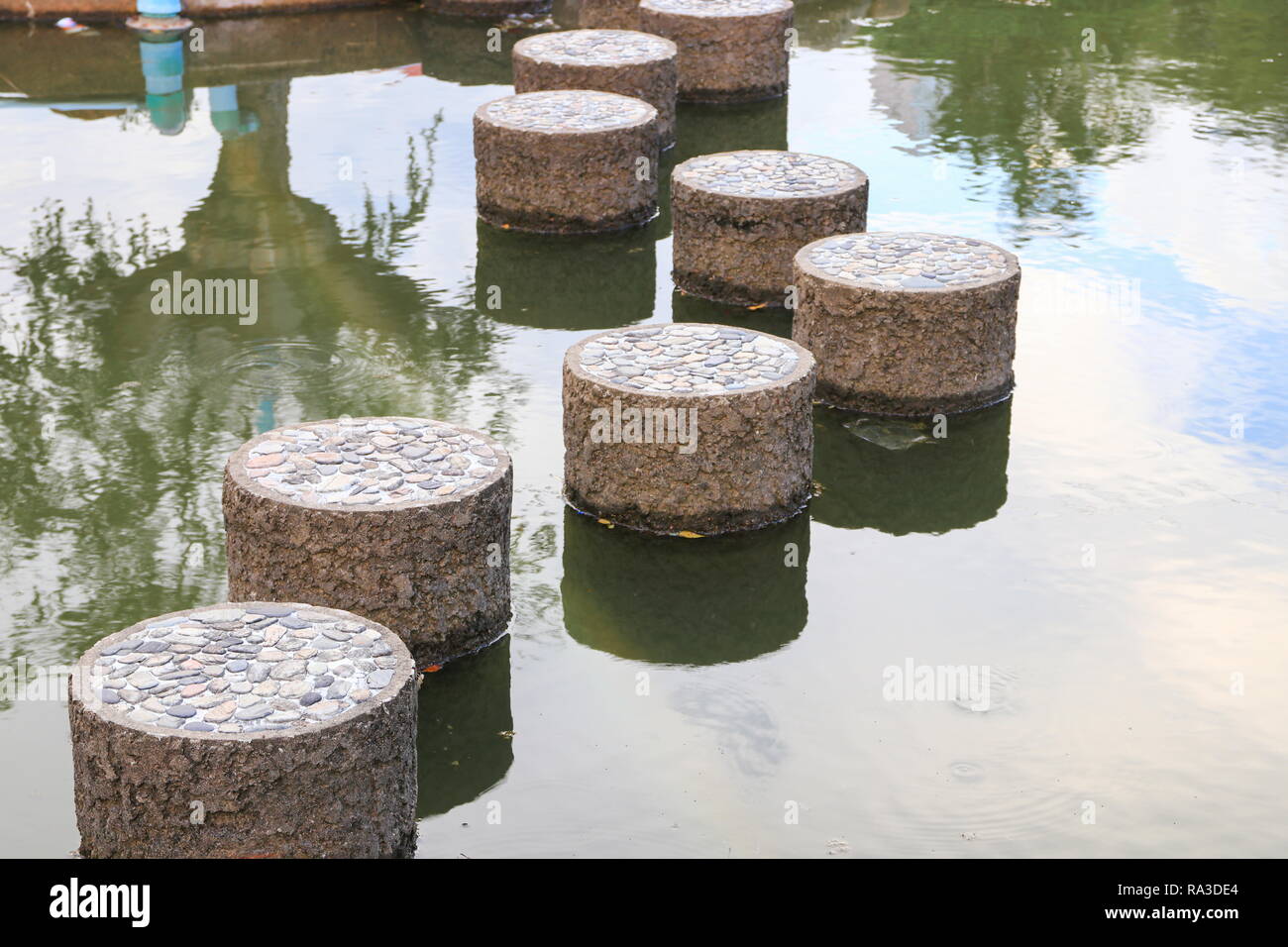 stone walkway across the pool in public park select focus with shallow ...