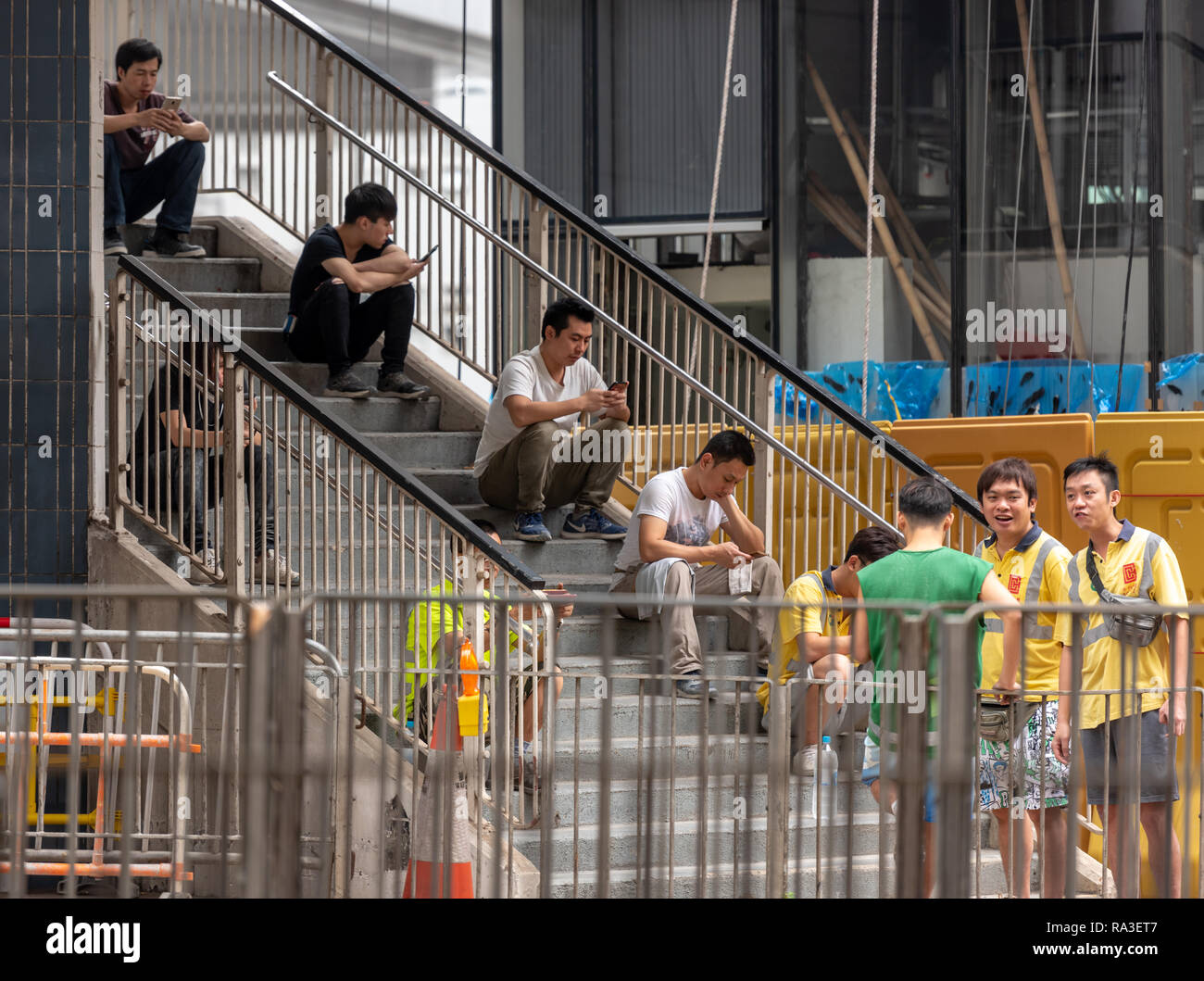 Screen time: workers rest from the midday sun in the shade of a ...