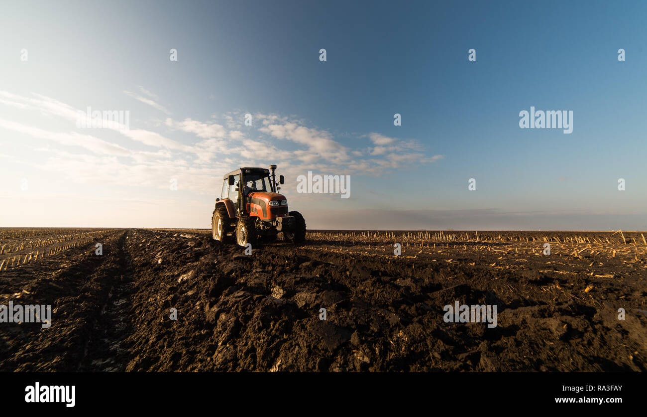 Tractors plowing stubble fields Stock Photo - Alamy