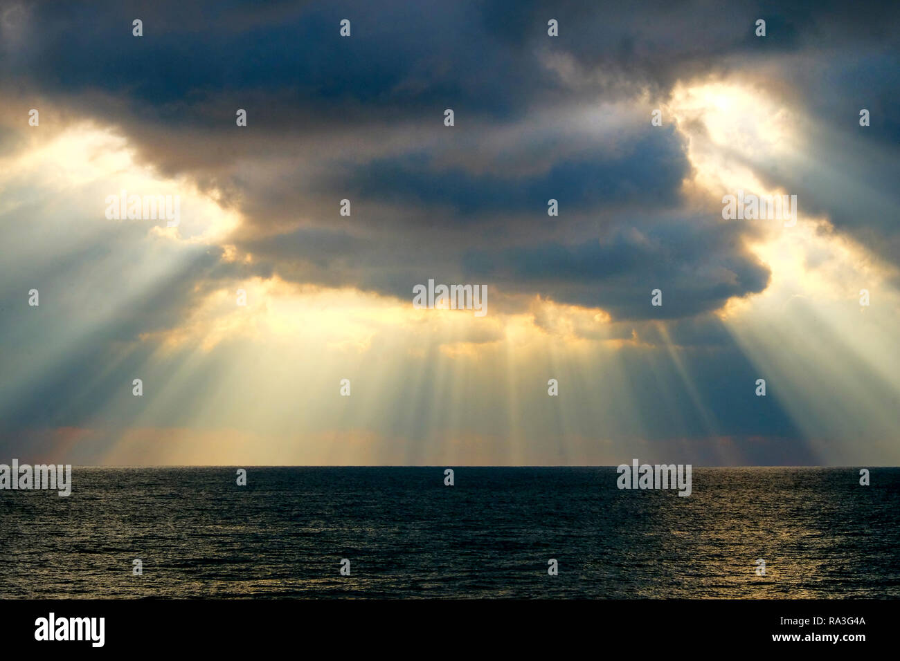 lots of long beams of sunlight shining through dramatic clouds casting ...