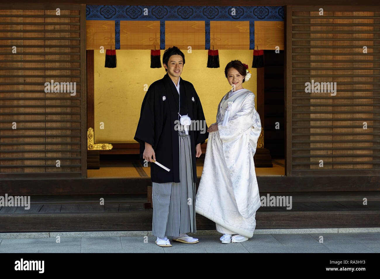 Bride and groom in traditional dressess posing in the Meiji Jingu ...