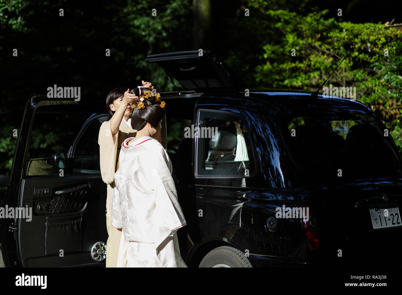 Shinto bride wearing the traditional white dress preparing to go in the ...