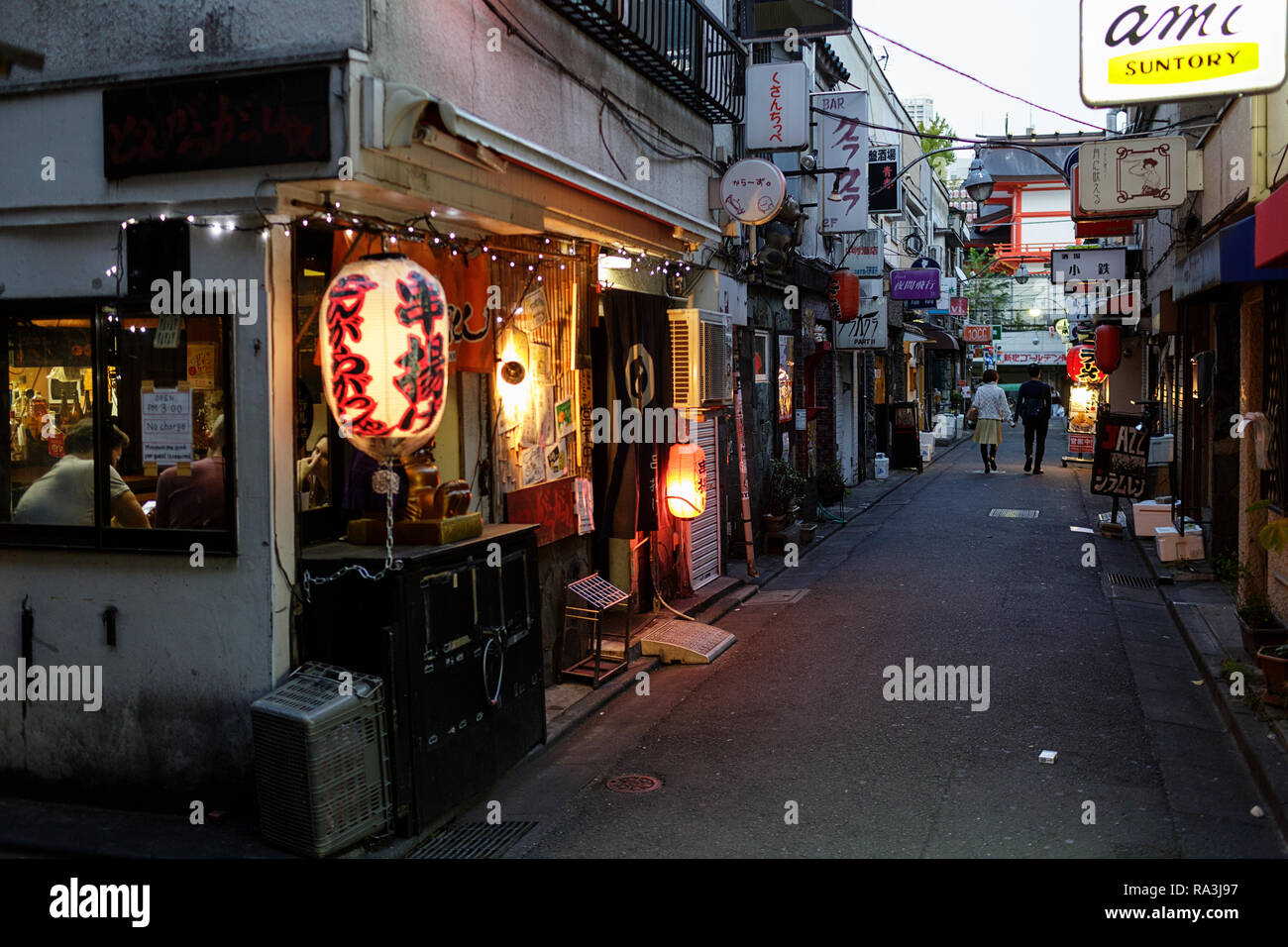 Couple holding hands while walking by traditional Tokyo street ...