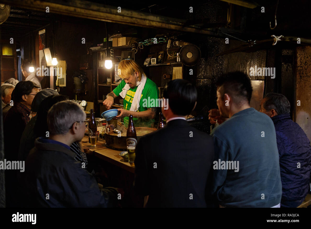 A Japanese chef cooks at Hot and smoky Tokyo street restaurant, as ...