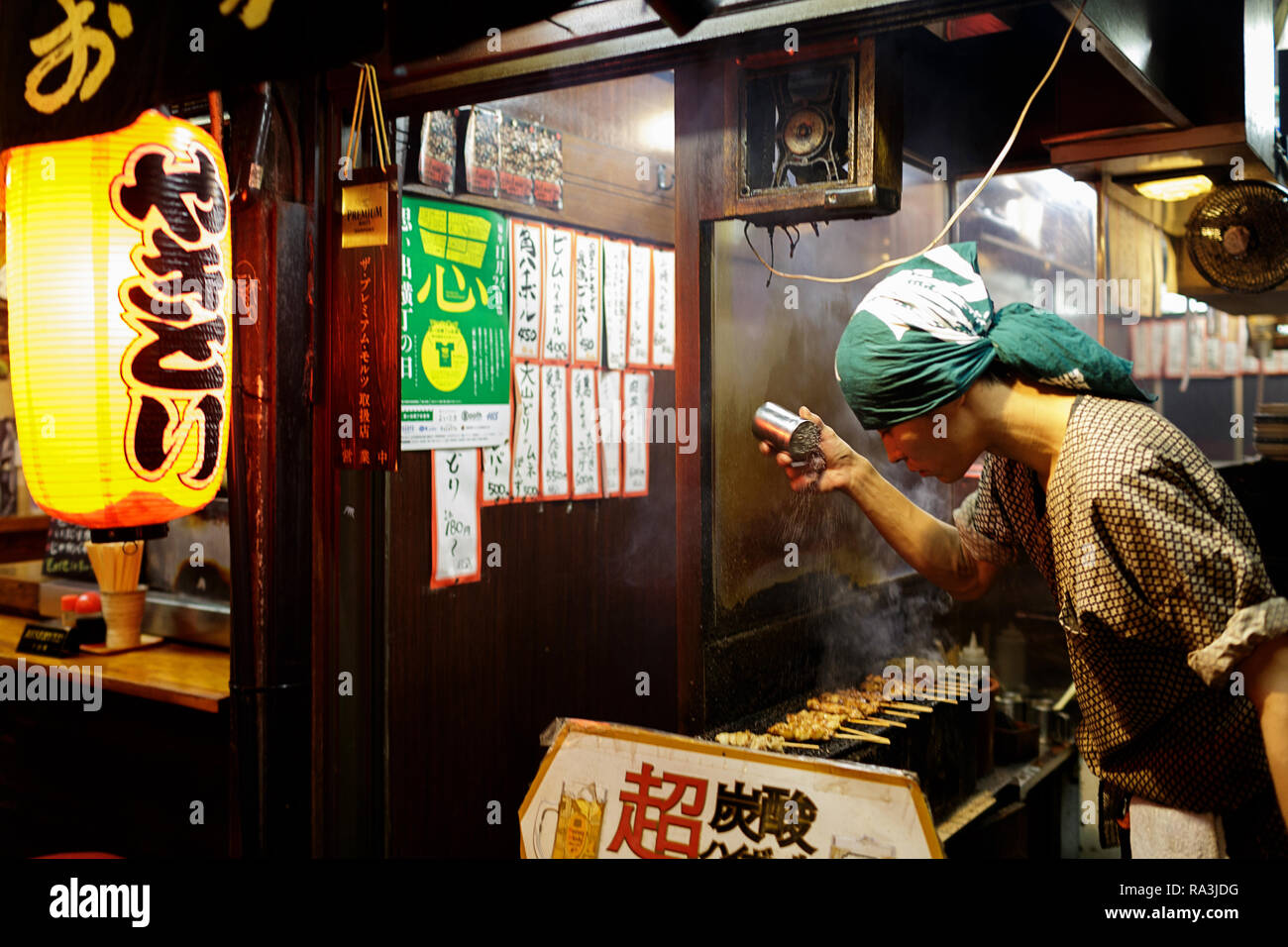A Japanese chef cooks at Hot and smoky Tokyo street restaurant, as ...
