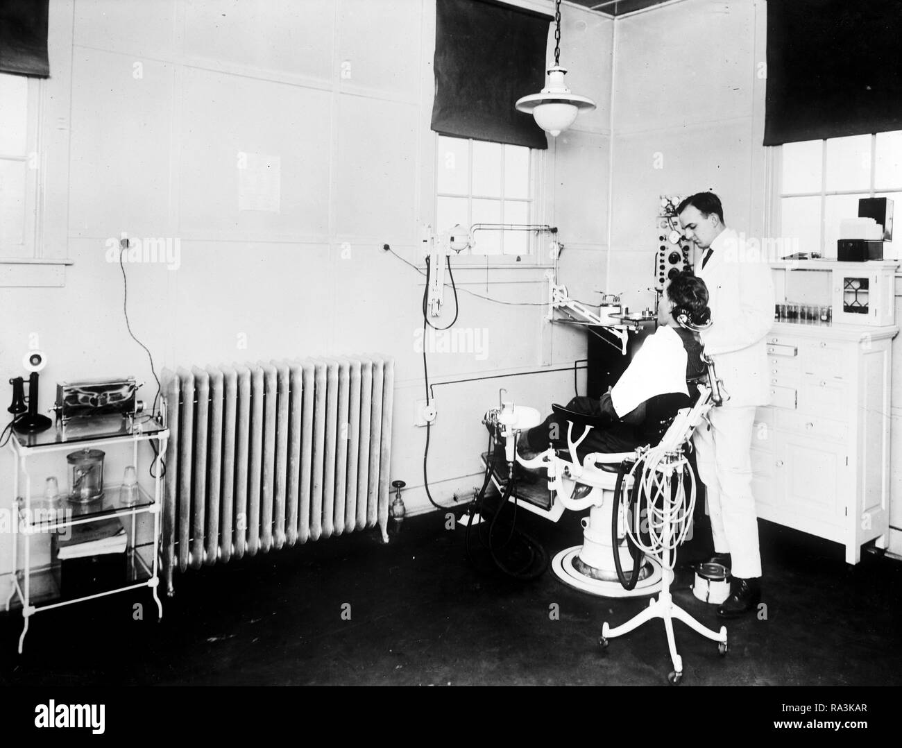 Patient and dentist inside early 1900s dental office Stock Photo - Alamy