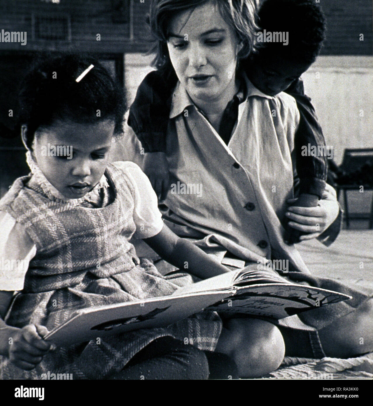 A teacher is reading with two African American children ca. 1950s Stock ...