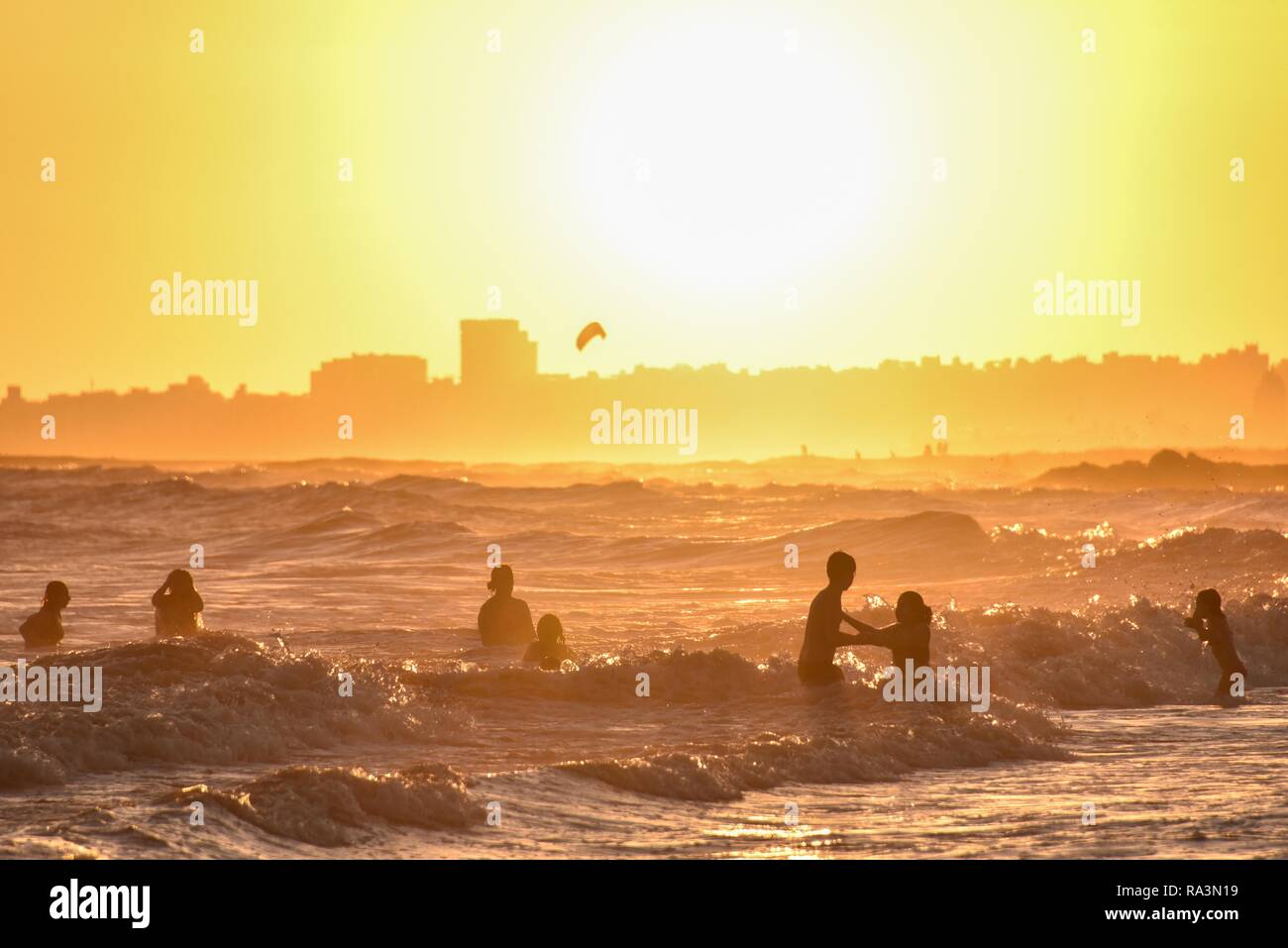People bathing on the beach at sunset, beach Rambla, Montevideo ...