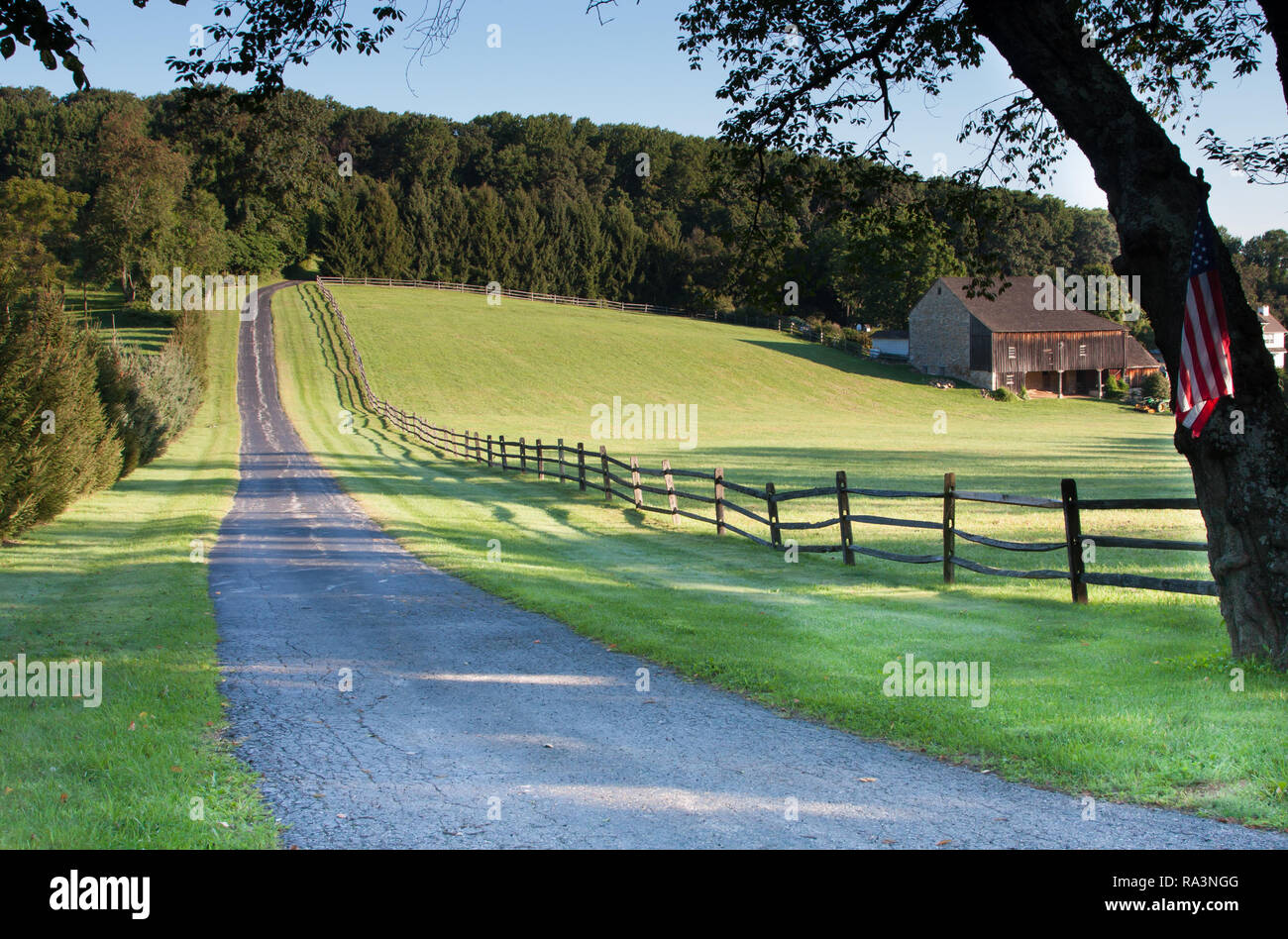 Fence lined road leading to farm and fields Stock Photo - Alamy