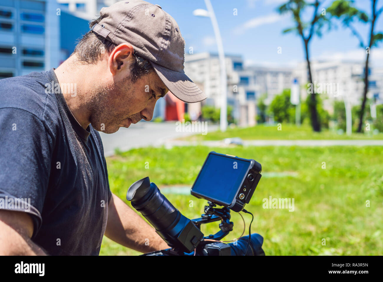 a professional cameraman prepares a camera and a tripod before shooting ...