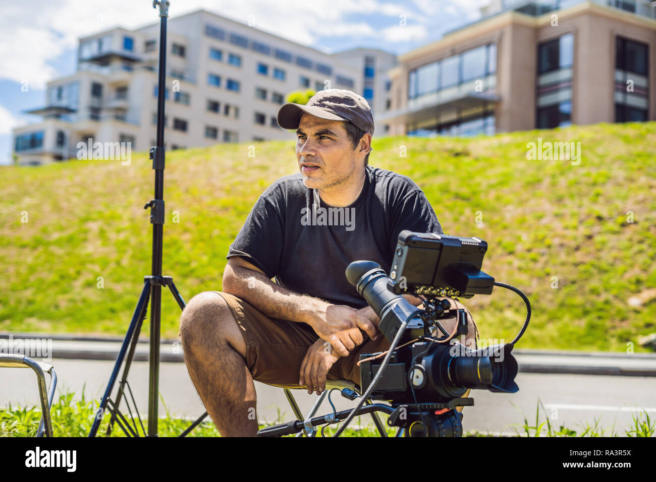 a professional cameraman prepares a camera and a tripod before shooting ...
