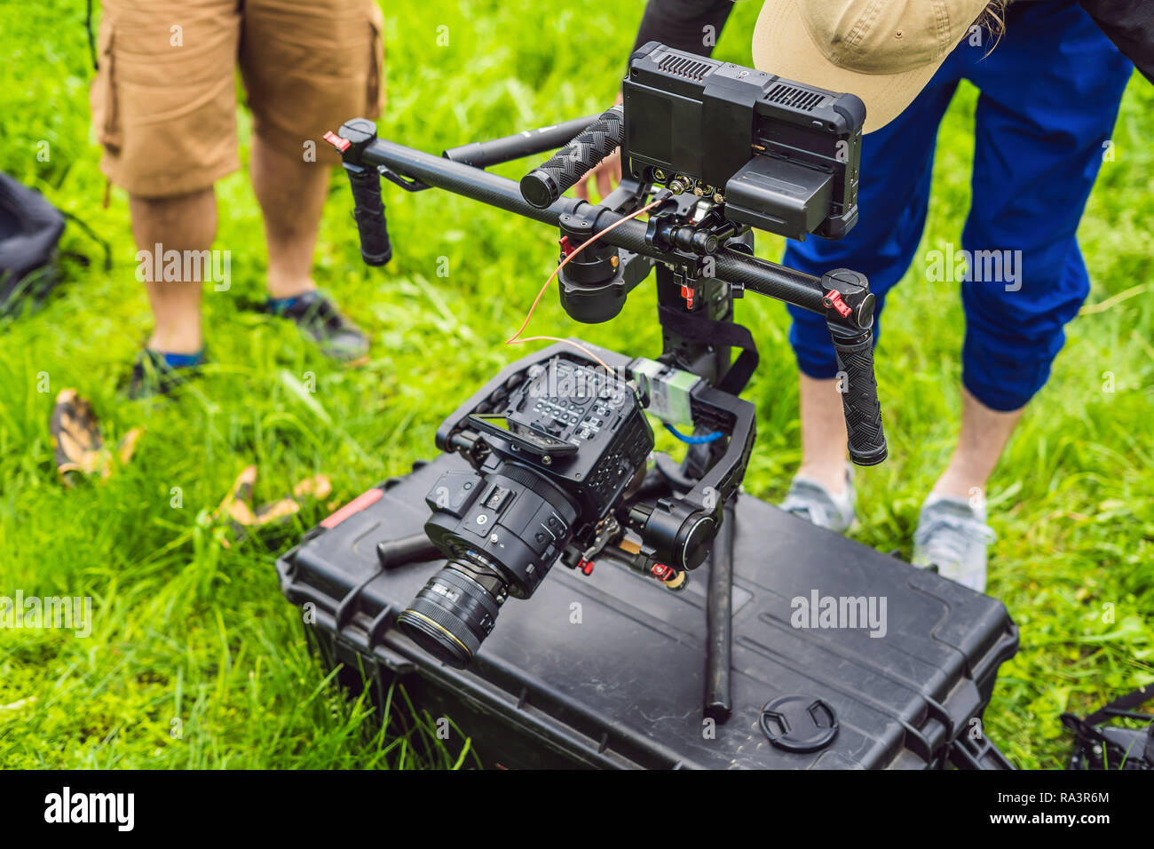 Cameraman setting up heavy duty professional 3-axis gimbal stabilizer ... Cameraman setting up heavy duty professional 3-axis gimbal stabilizer ...