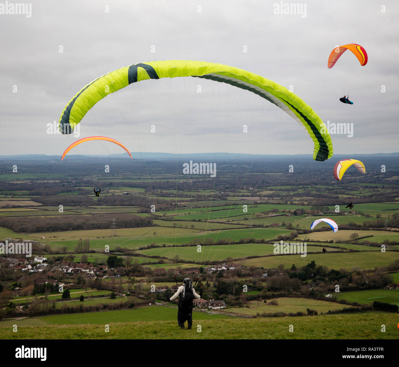 Aerial view of Paragliding kites flying off Devils Dyke, South Downs ...