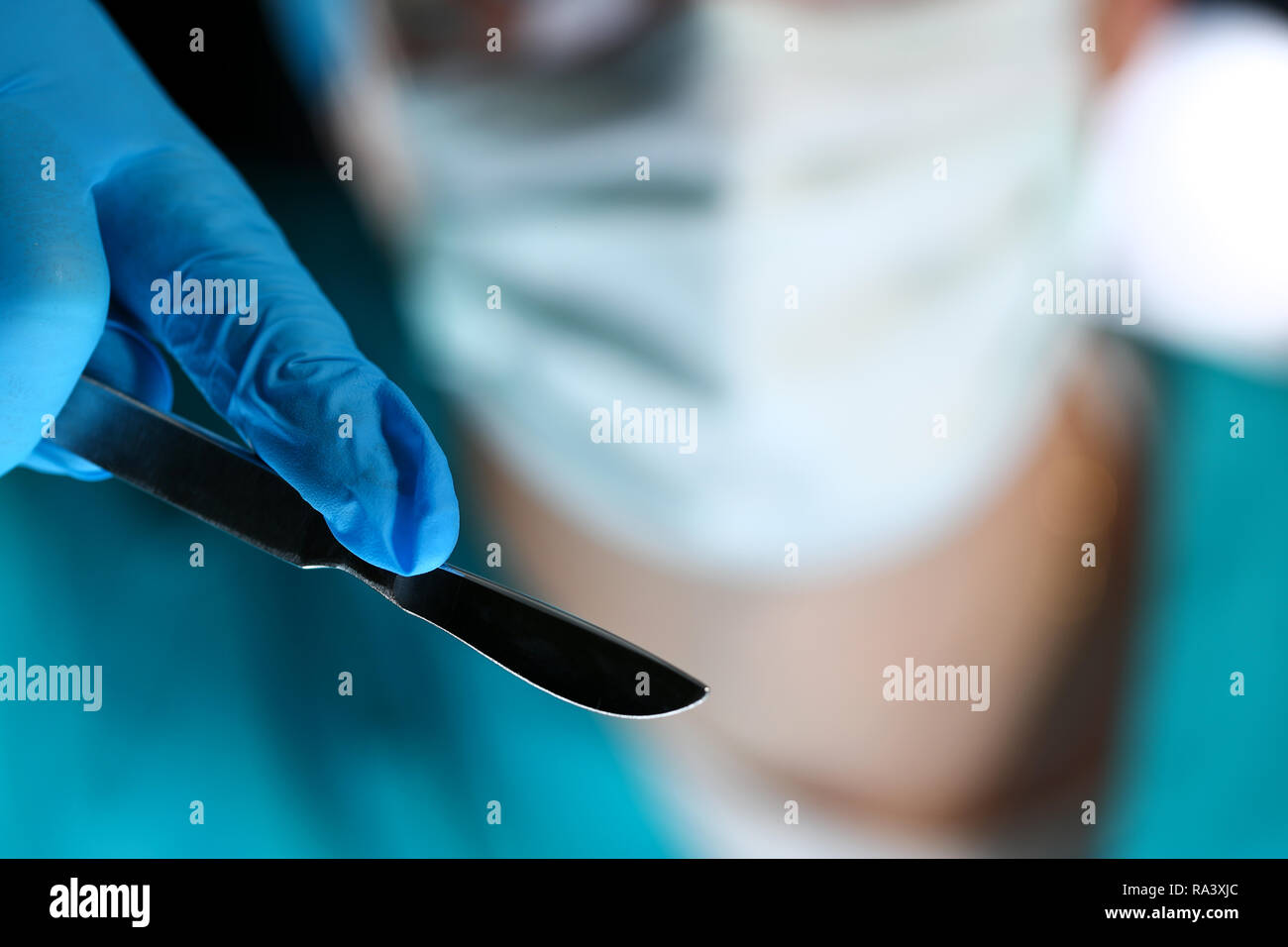 Surgeon arms in sterile uniform holding sharp knife Stock Photo - Alamy