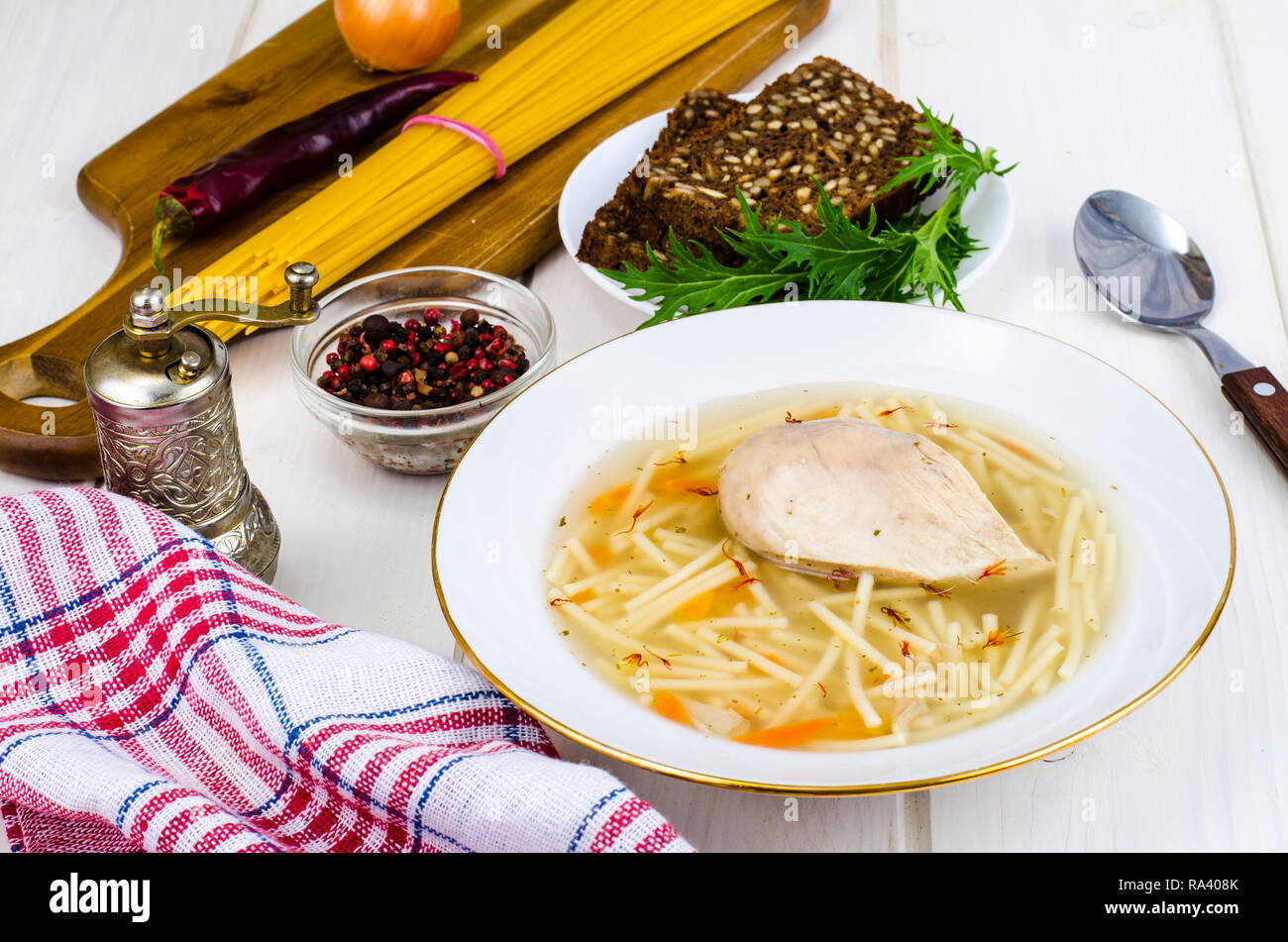 Chicken broth noodle soup on white wooden background. Studio Photo ...