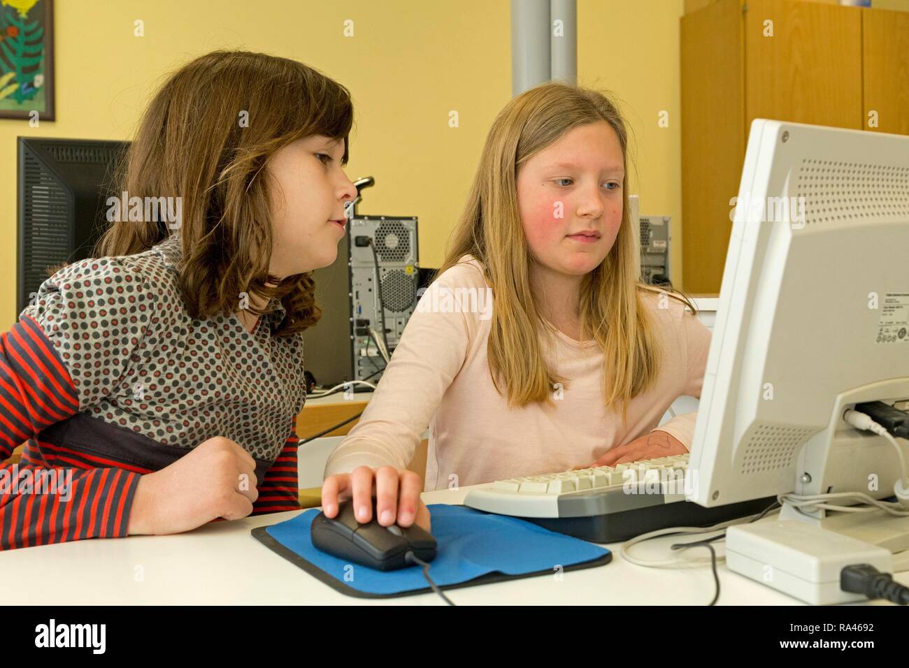 Elementary school girls working in computer room, Lower Saxony, Germany ...