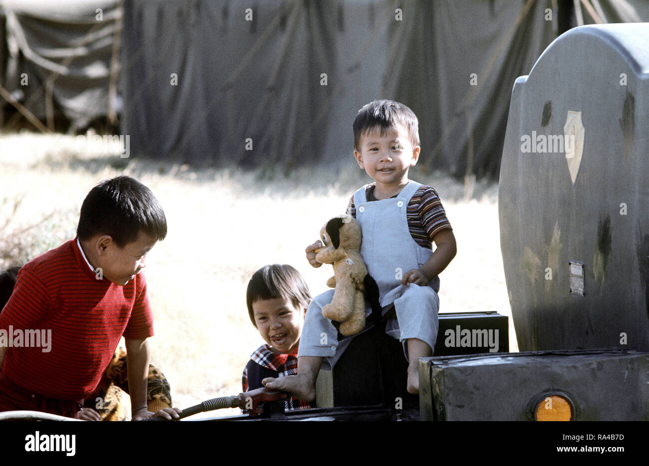 1975 - Children play on a piece of equipment at a temporary housing ...