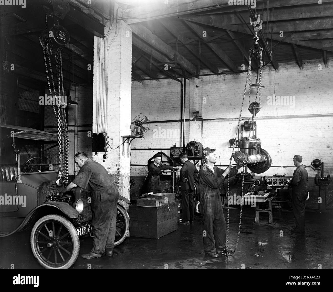 C&P Telephone Company,men working on automobiles in garage ca. early ...