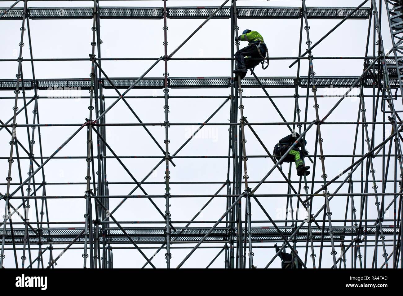 Scaffolders at work, building a large scaffolding, work at high ...