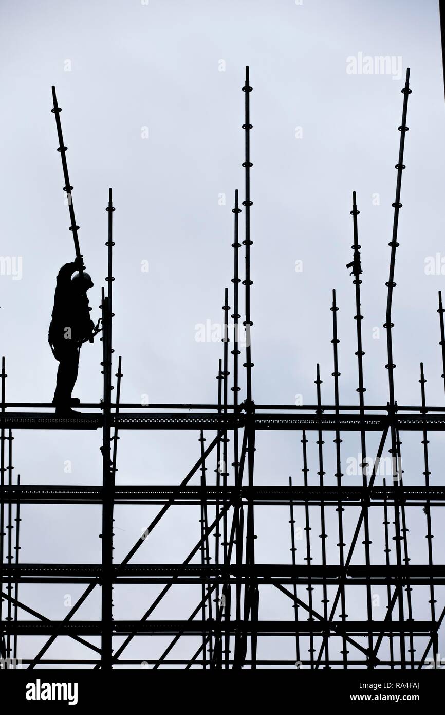 Scaffolders at work, building a large scaffolding, work at high ...