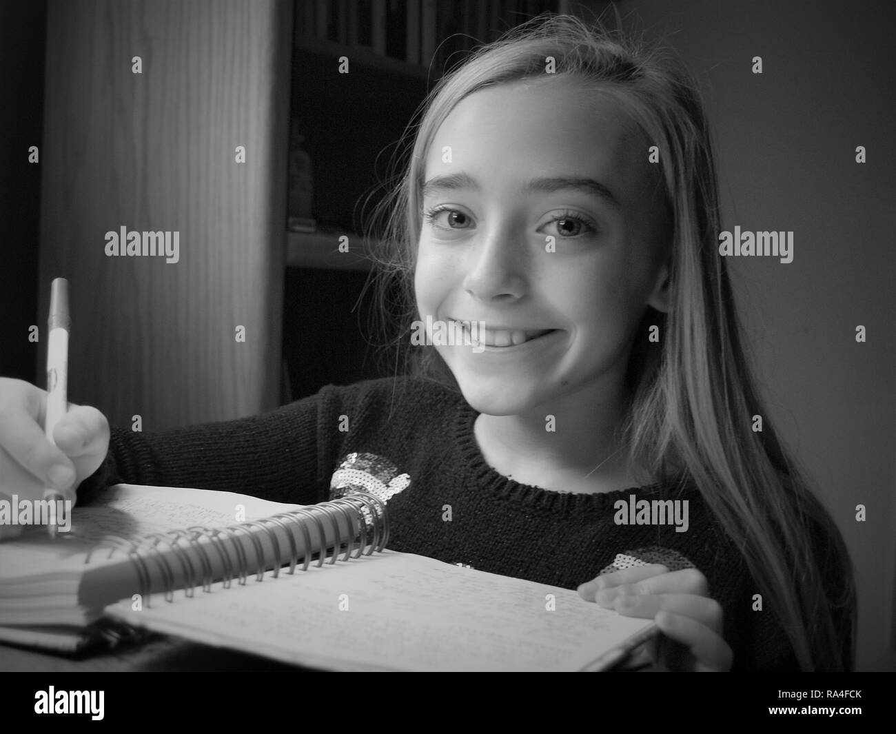 Young girl studying in black and white, holding pen Stock Photo - Alamy