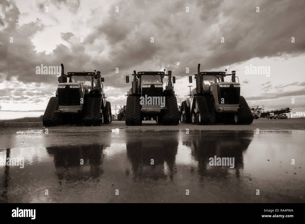 Three large modern agriculture tractors with triangular tracks for ...