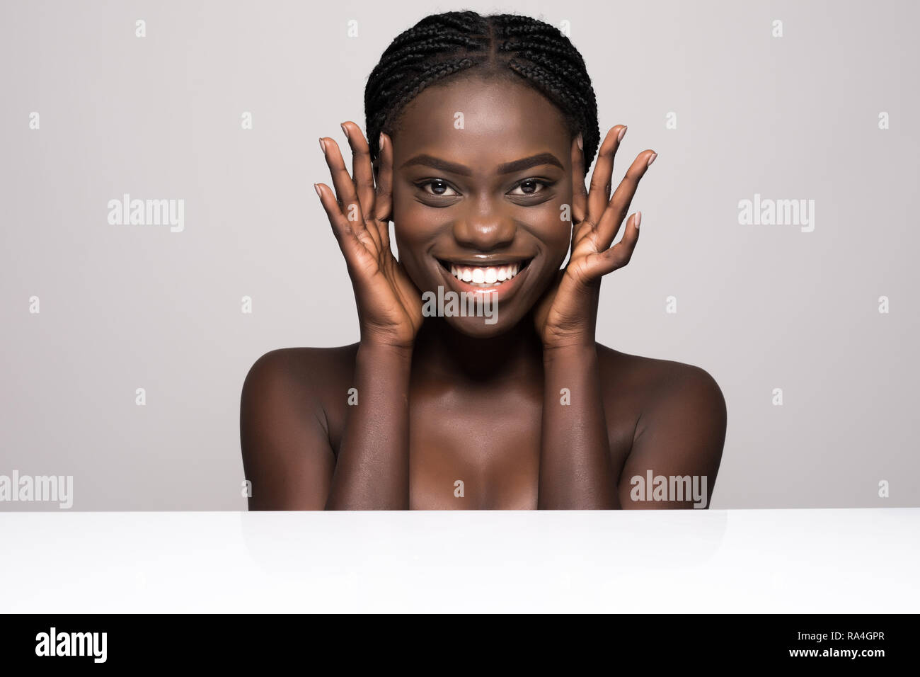 Beautiful Model Applying Cosmetic Cream Treatment On Her Face On White