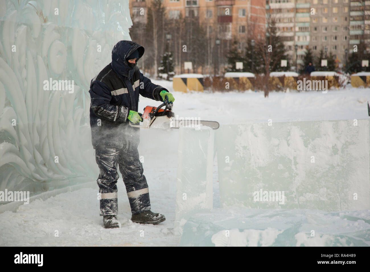Worker saws a chainsaw ice plate in an ice town Stock Photo - Alamy