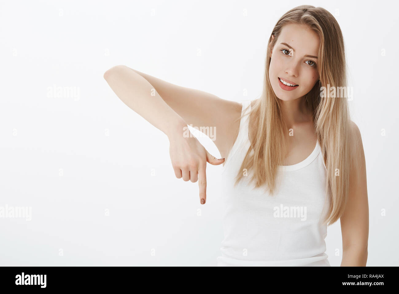 Girl pressing button as pointing down with index finger smiling ...
