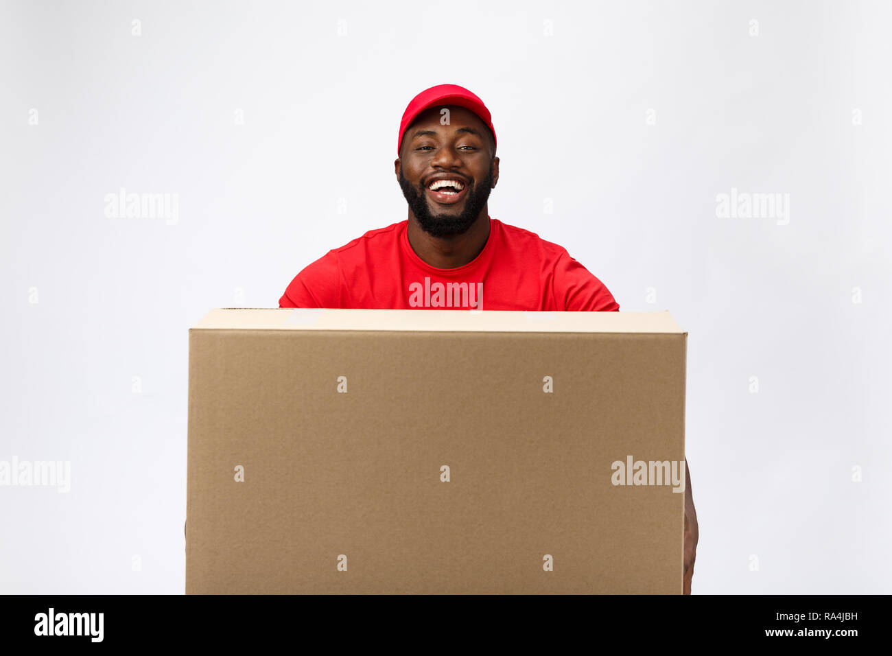 Delivery Concept - Handsome African American delivery man carrying ...