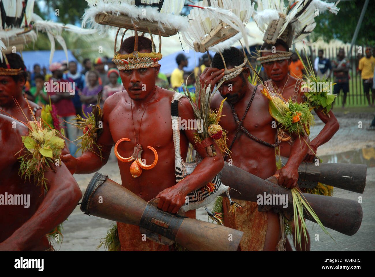 Colourfully dressed and face painted men and women dancing as part of a ...