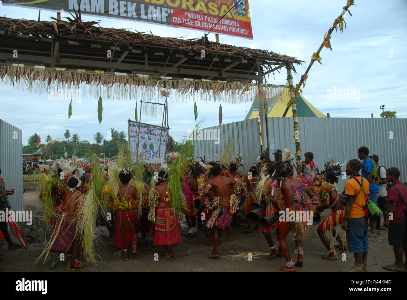 Colourfully dressed and face painted men and women dancing as part of a ...
