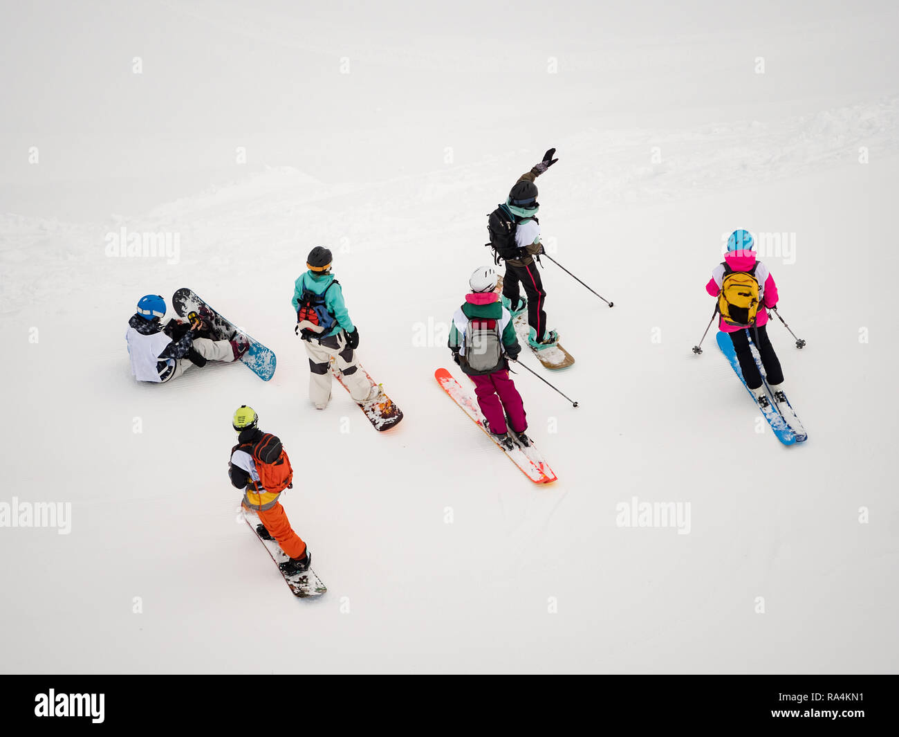 group of girls skiers and snowboarders freeriders stand in the snow and ...