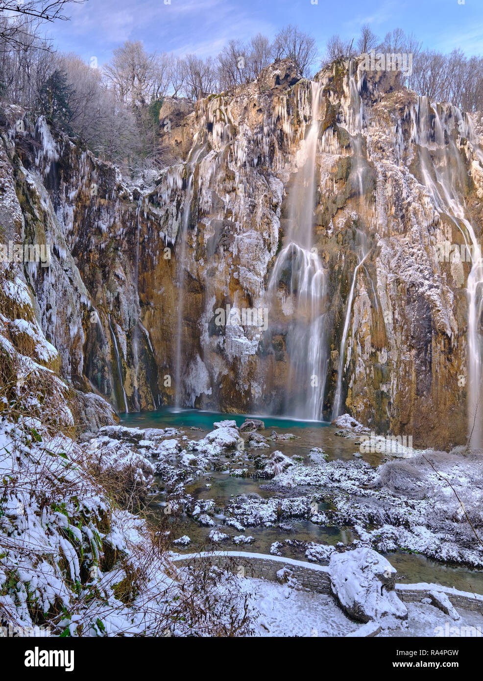 Portrait of Frozen big waterfall, covered in snow and ice falling into ...