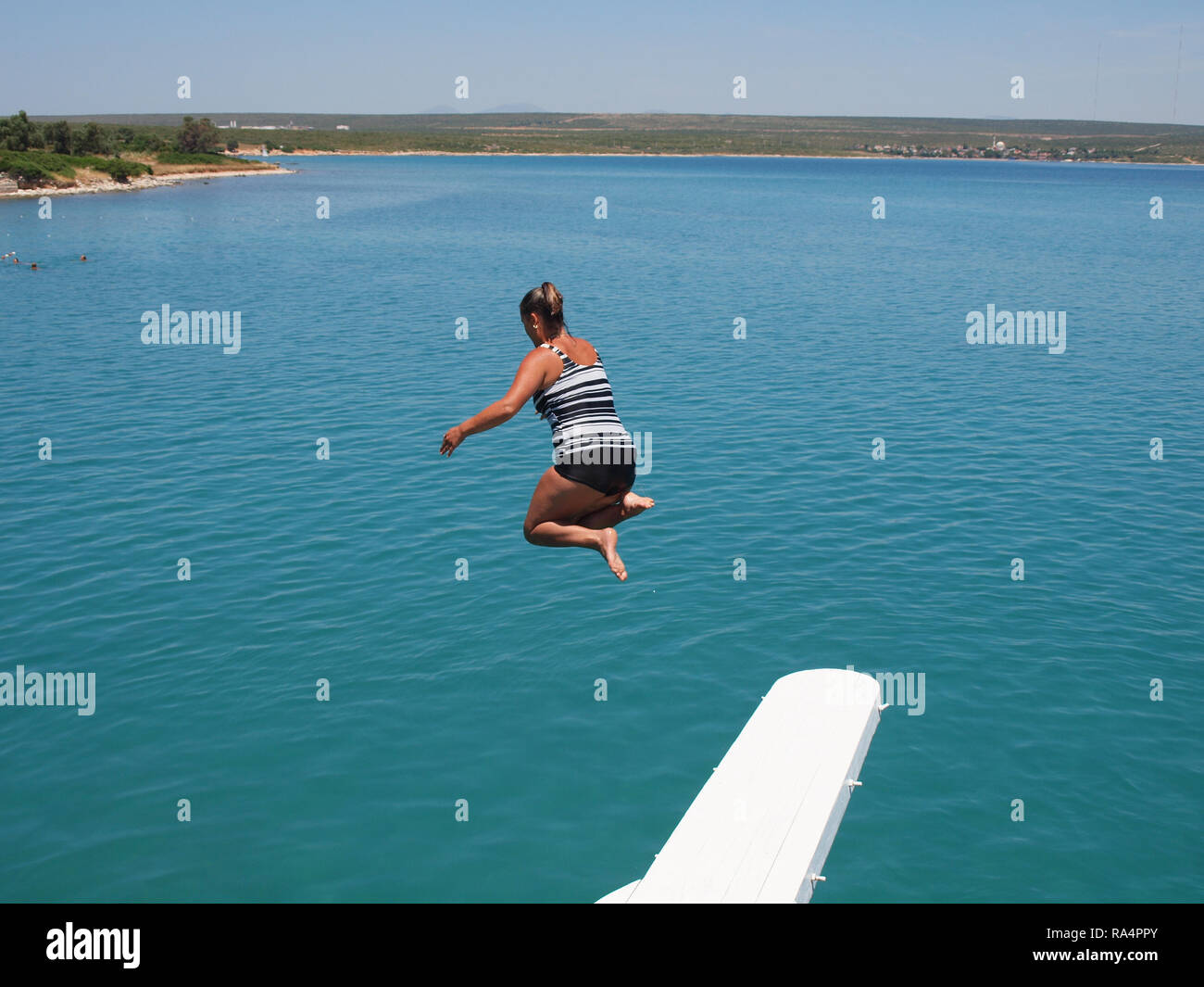 Woman jumping off a boat hi-res stock photography and images - Alamy