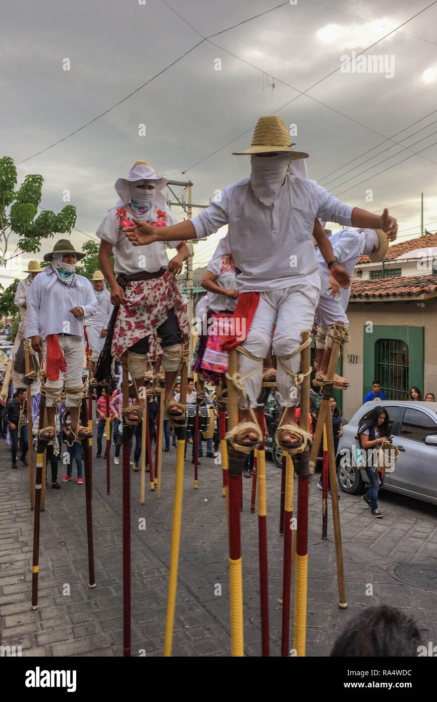 Close up shot of stilt-walkers in the street in traditional clothing ...