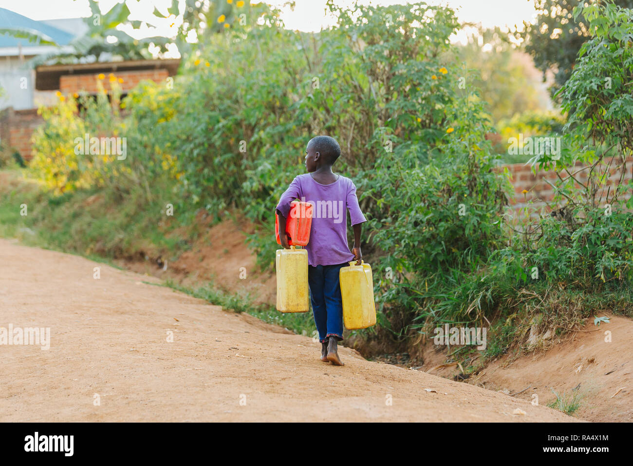 Child carrying water in Uganda, Africa Stock Photo - Alamy