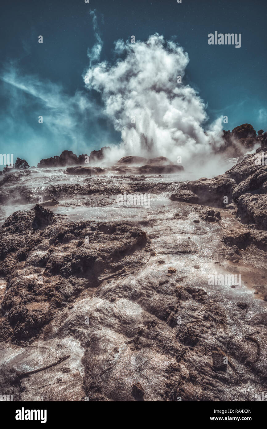 Vertical fountain of geothermal steam on volcanic ground, viewed from ...