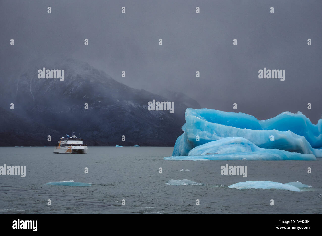 Tour boat looking at blue icebergs from a glacier in Argentina on a ...