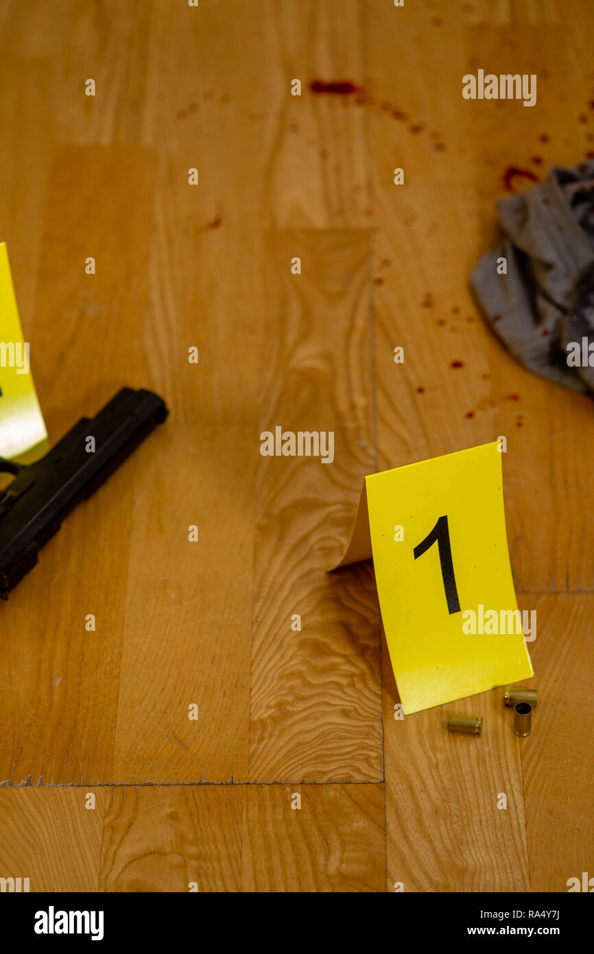 Bullets and gun next to markers at crime scene Stock Photo - Alamy