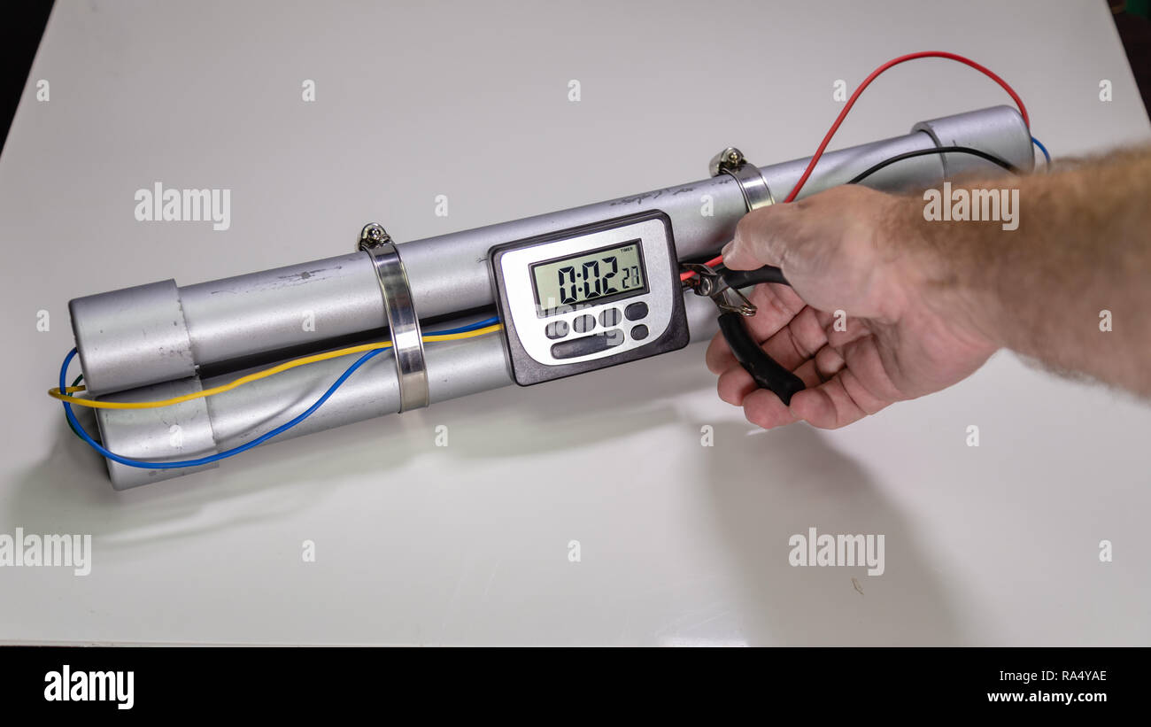 Hand cutting wire on pipe bomb with an lcd clock timer to trigger ...