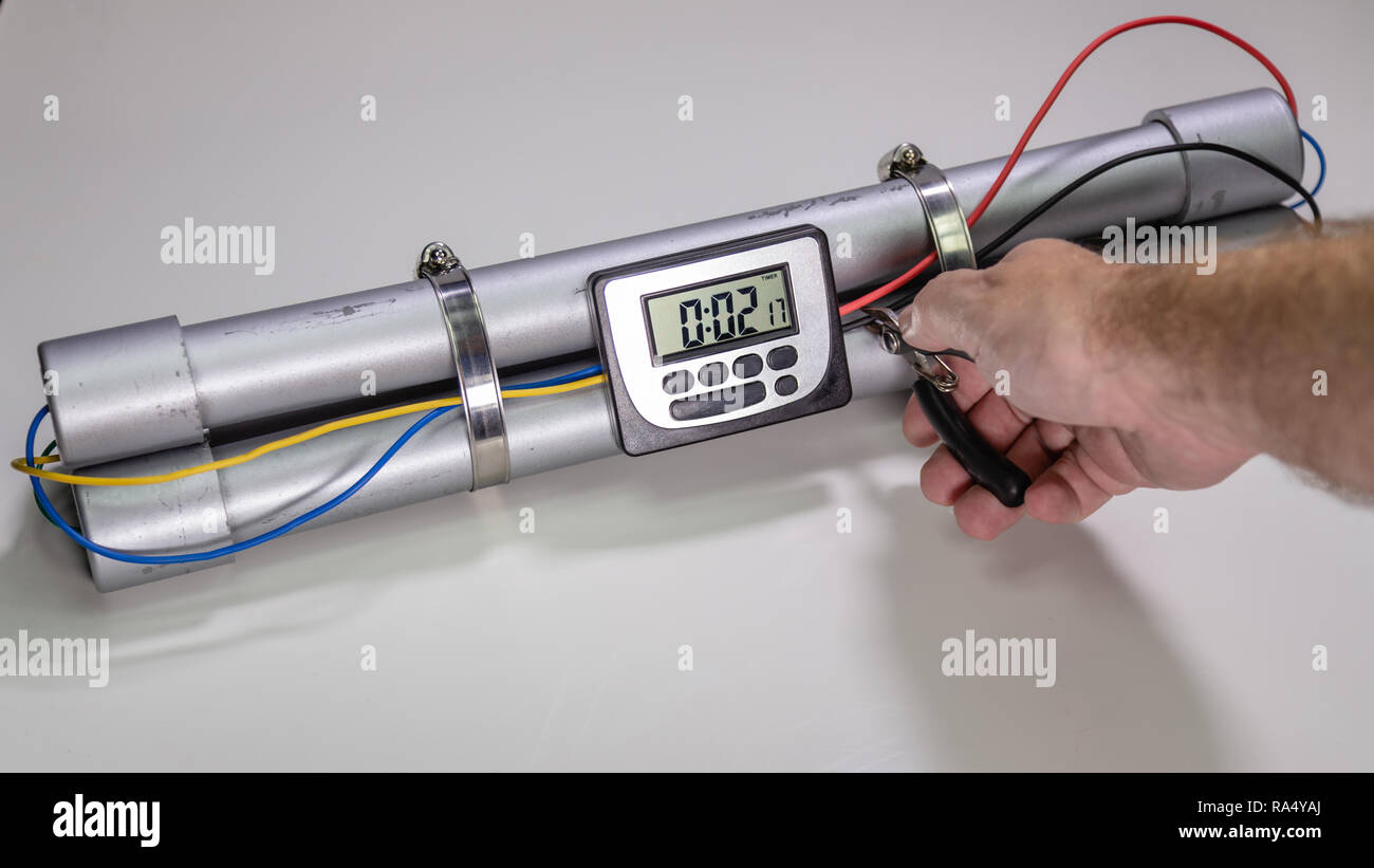 Hand cutting wire on pipe bomb with an lcd clock timer to trigger ...