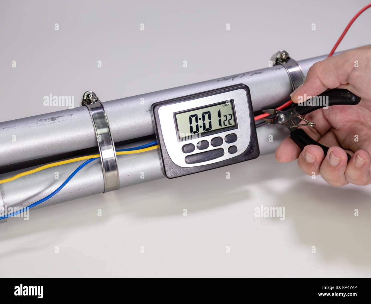 Hand cutting wire on pipe bomb with an lcd clock timer to trigger ...