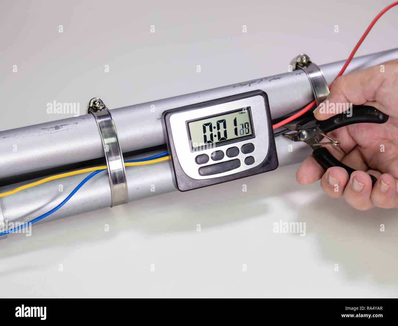 Hand cutting wire on pipe bomb with an lcd clock timer to trigger ...